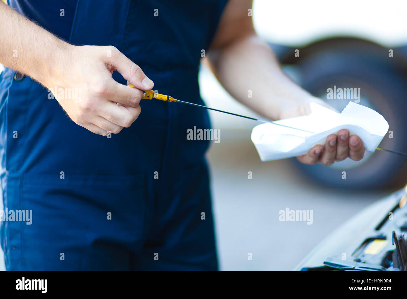 Mechanic measuring the oil level of an engine at an auto shop Stock ...