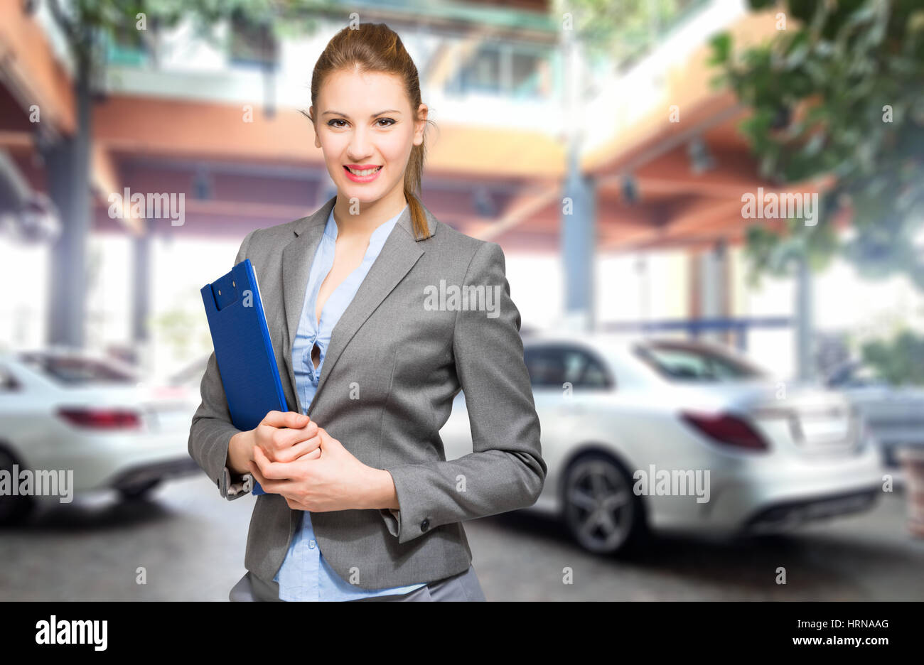 Smiling female car seller Stock Photo - Alamy