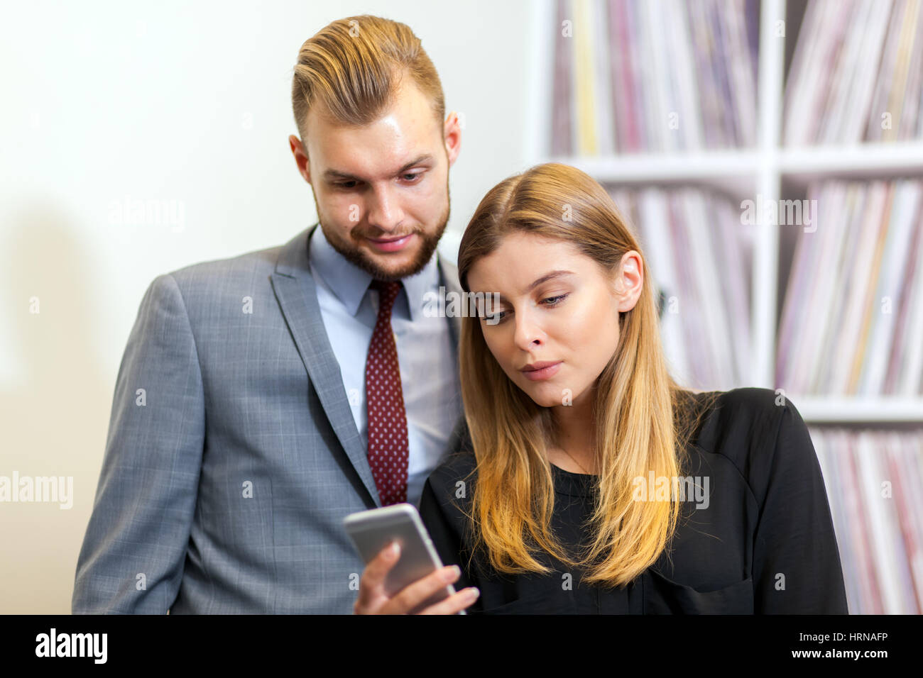 Business people using a mobile phone in their office Stock Photo - Alamy