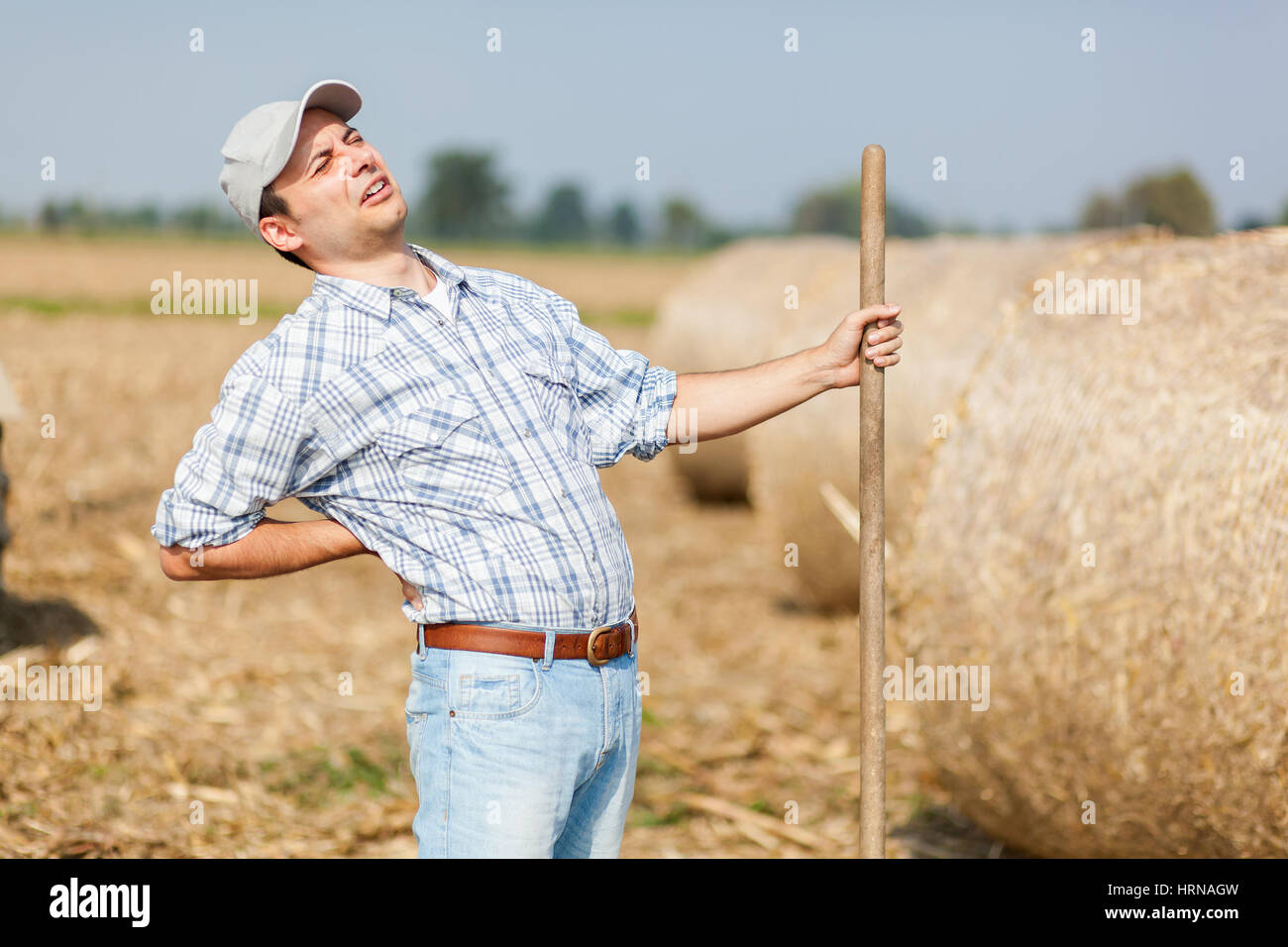 Farmer having back pain Stock Photo - Alamy