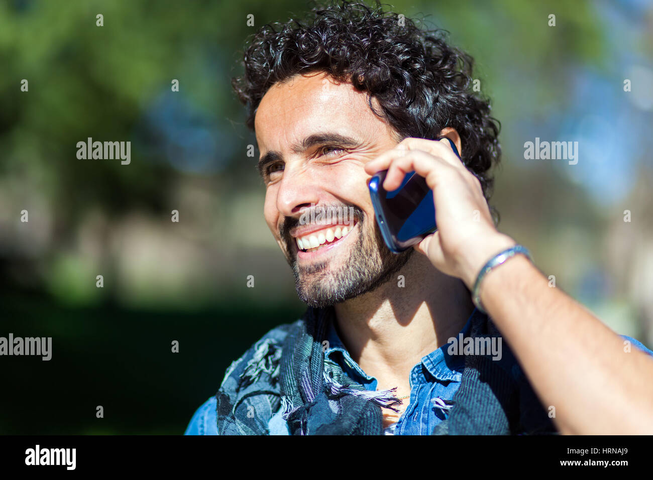 Handsome man phoning in the park Stock Photo - Alamy