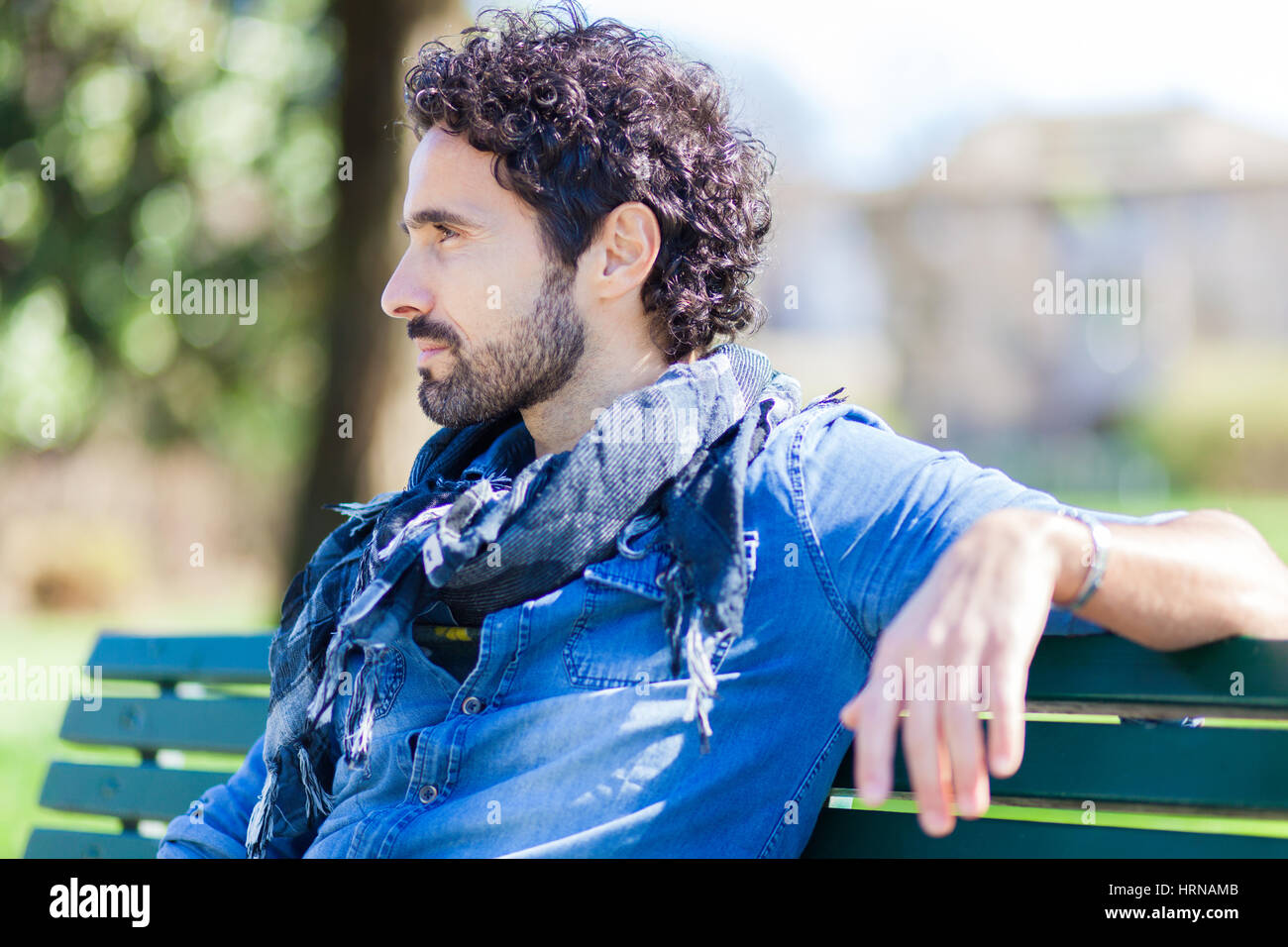 Portrait of a man sitting on a bench Stock Photo - Alamy
