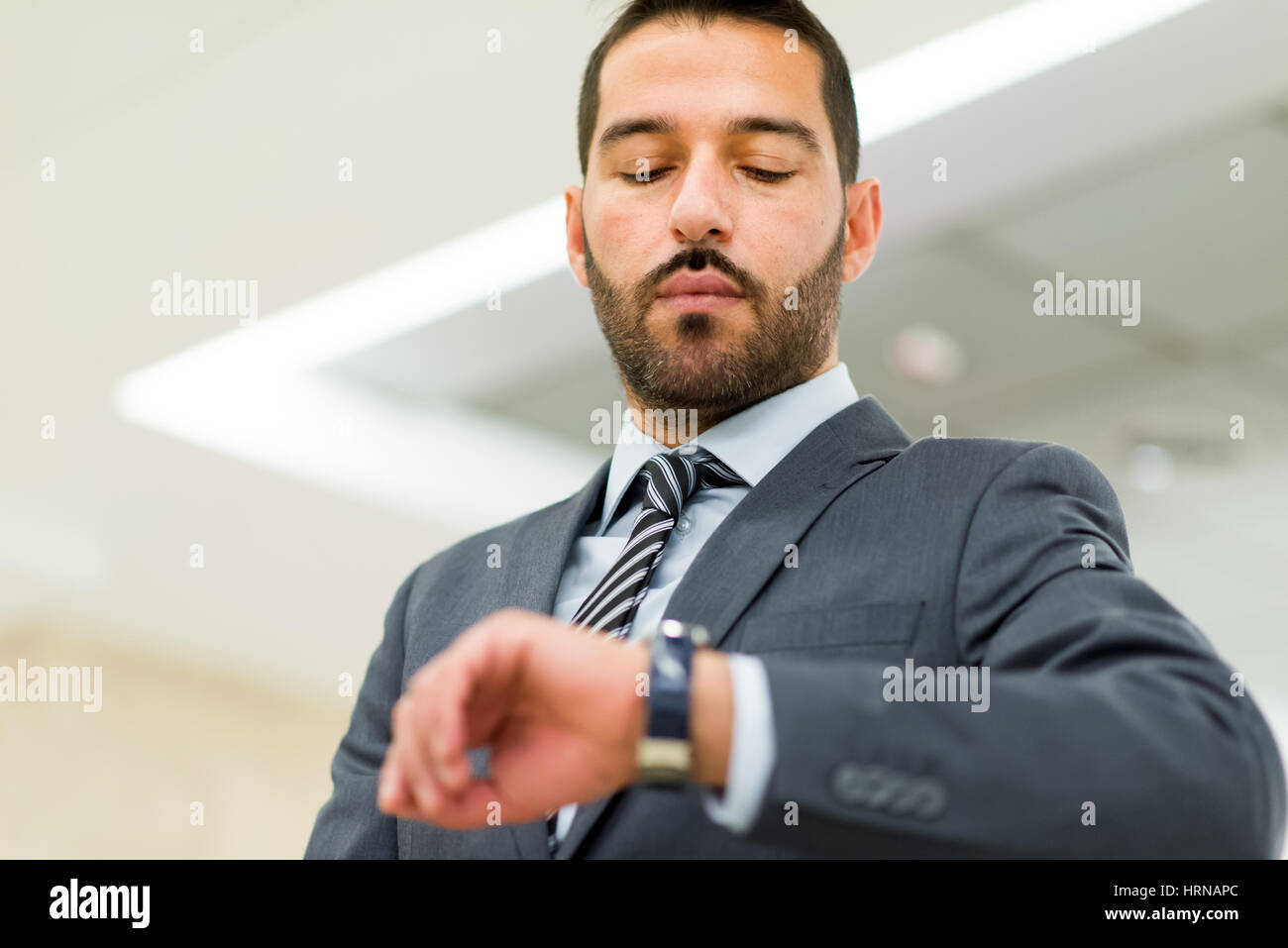 Businessman looking at his wrist watch Stock Photo - Alamy