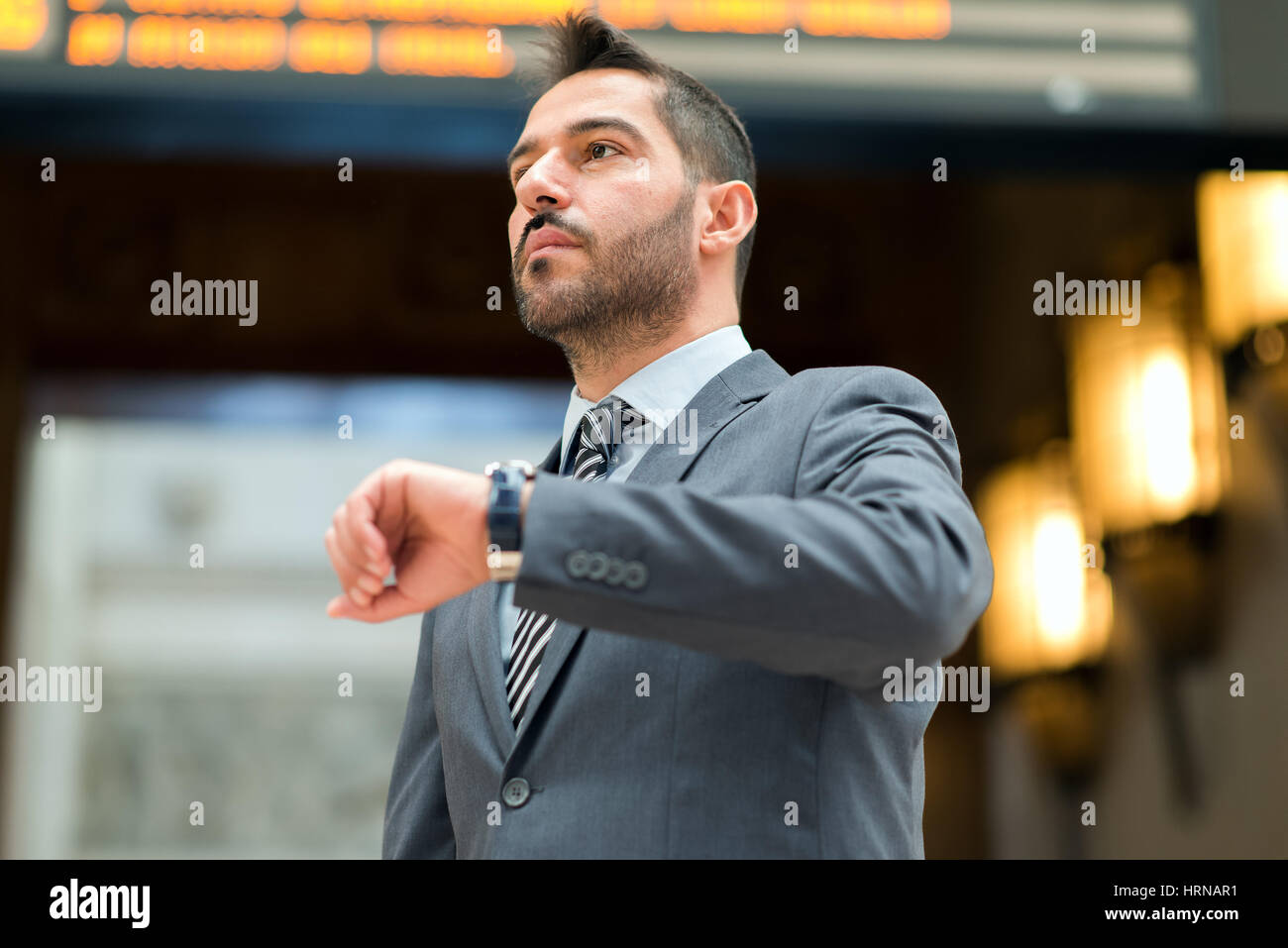 Man checking time in front of a timetable Stock Photo - Alamy