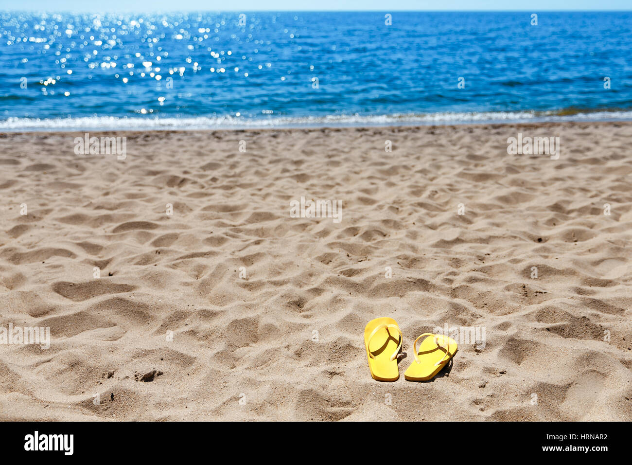 Yellow beach slippers on sandy beach, summer, bathing Stock Photo - Alamy
