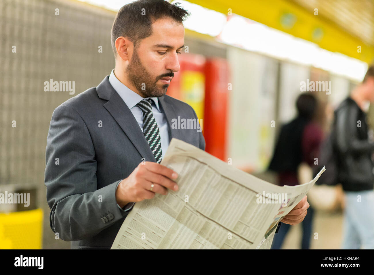 Commuter reading a newspaper while waiting for the subway train Stock ...