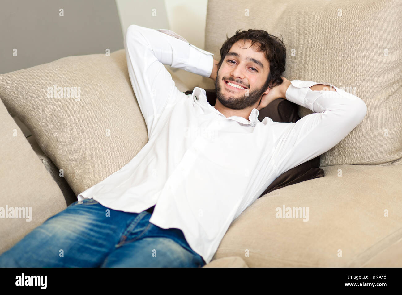 Young man relaxing on the couch Stock Photo - Alamy