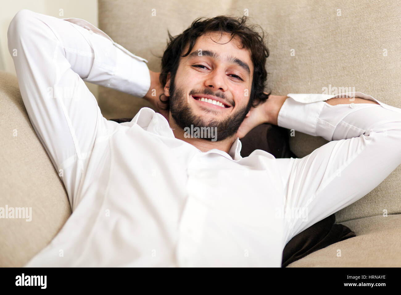 Young man relaxing on the couch Stock Photo - Alamy