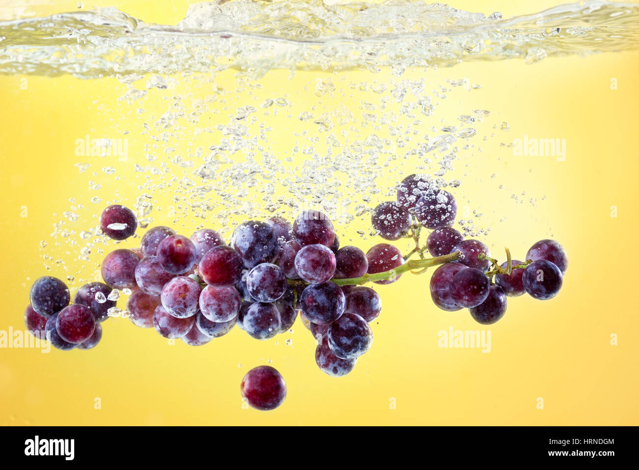 Falling grapes fruits to tank with water background Stock Photo - Alamy