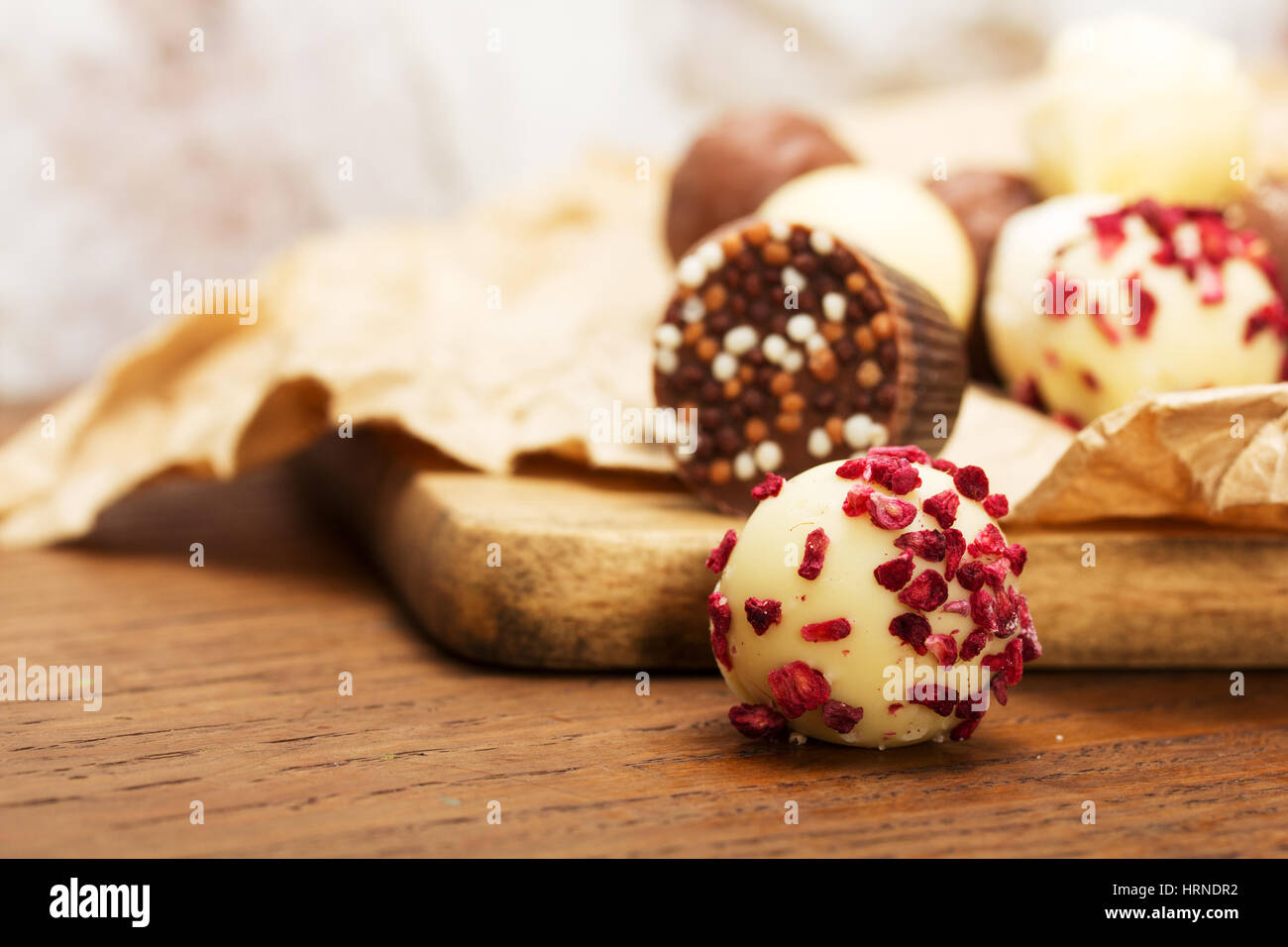 Selection of delicious chocolates on rustic background Stock Photo - Alamy