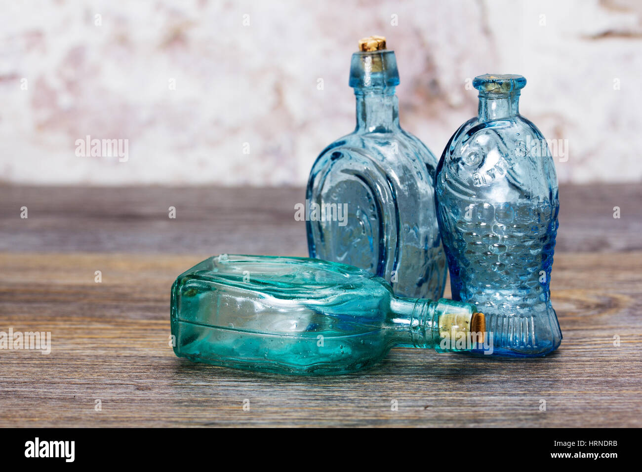 Selection of coloured glass bottles on a rustic background Stock Photo ...