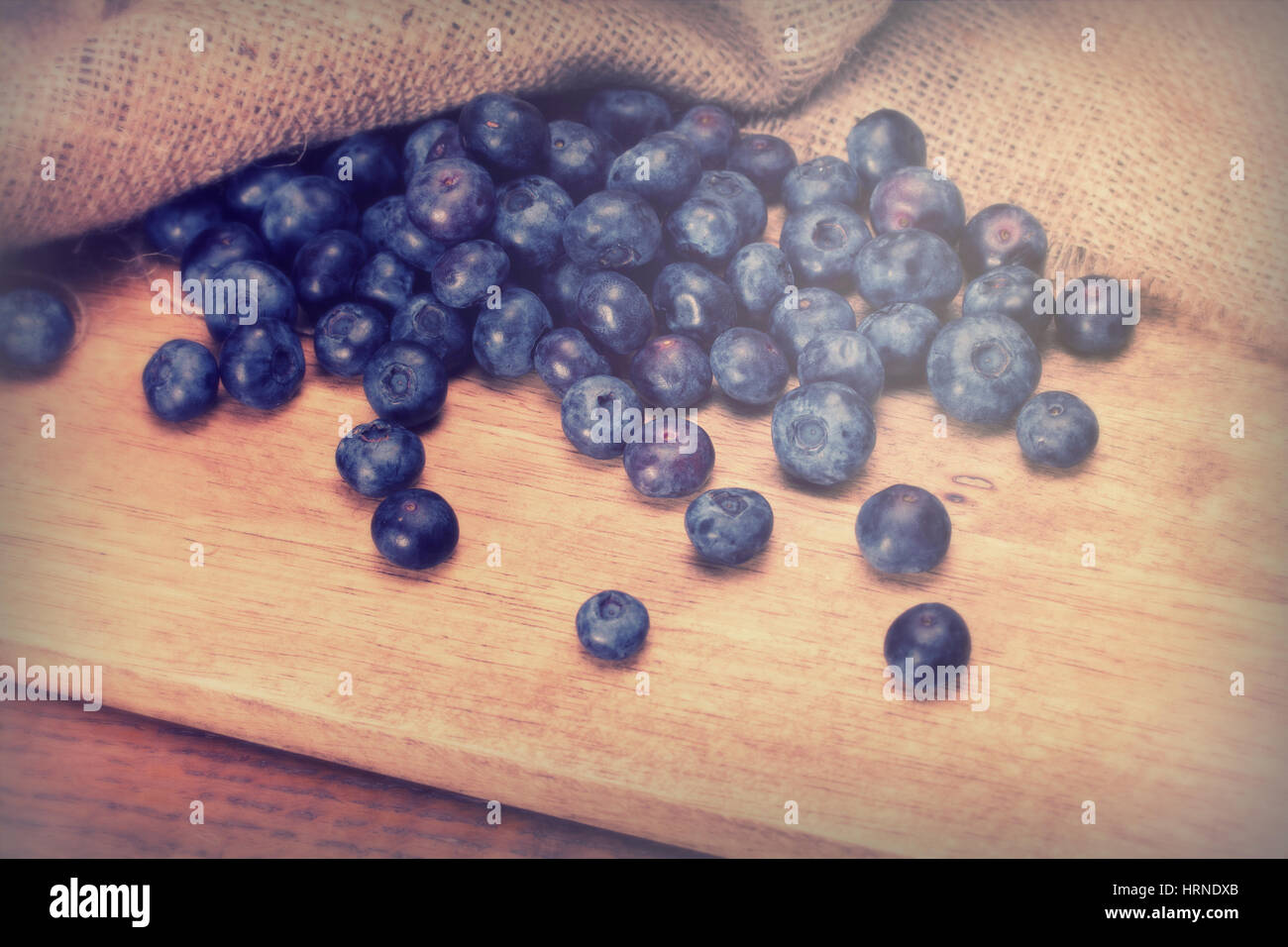 Blueberries spilt over a rustic wooden background Stock Photo - Alamy
