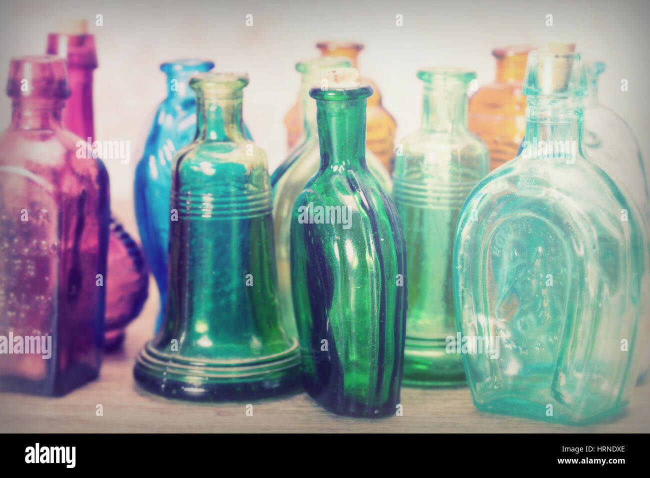 Selection of coloured glass bottles on a rustic background Stock Photo ...