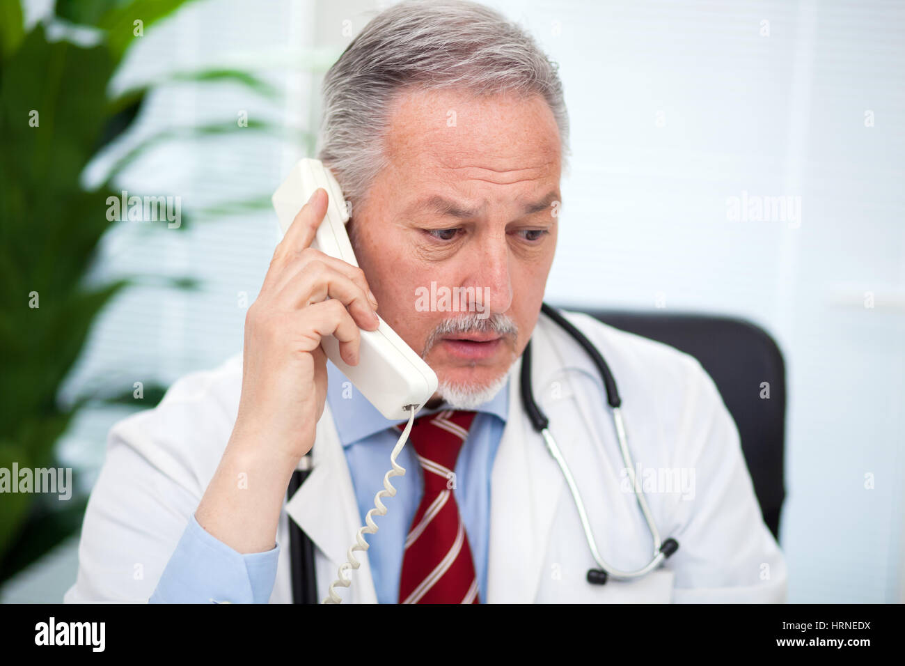 Male doctor using telephone hi-res stock photography and images - Alamy