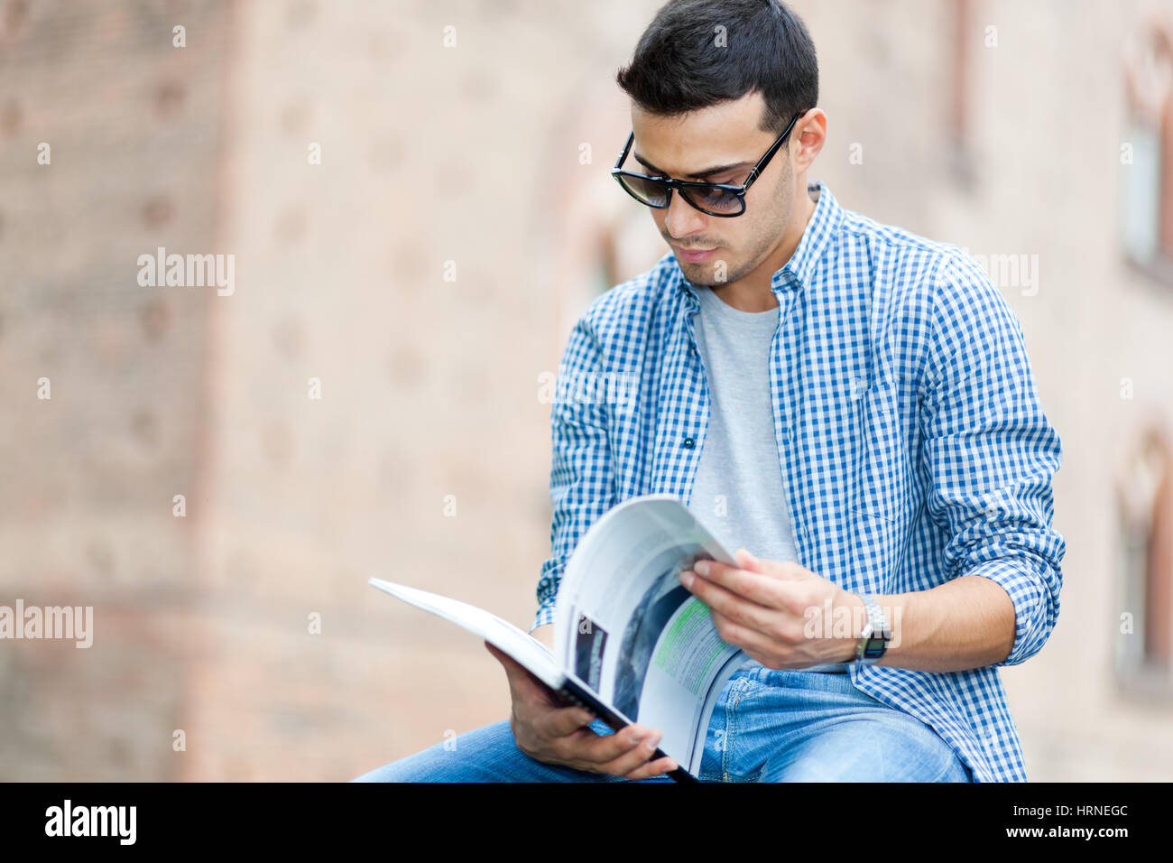 Young student reading a book outdoor Stock Photo - Alamy