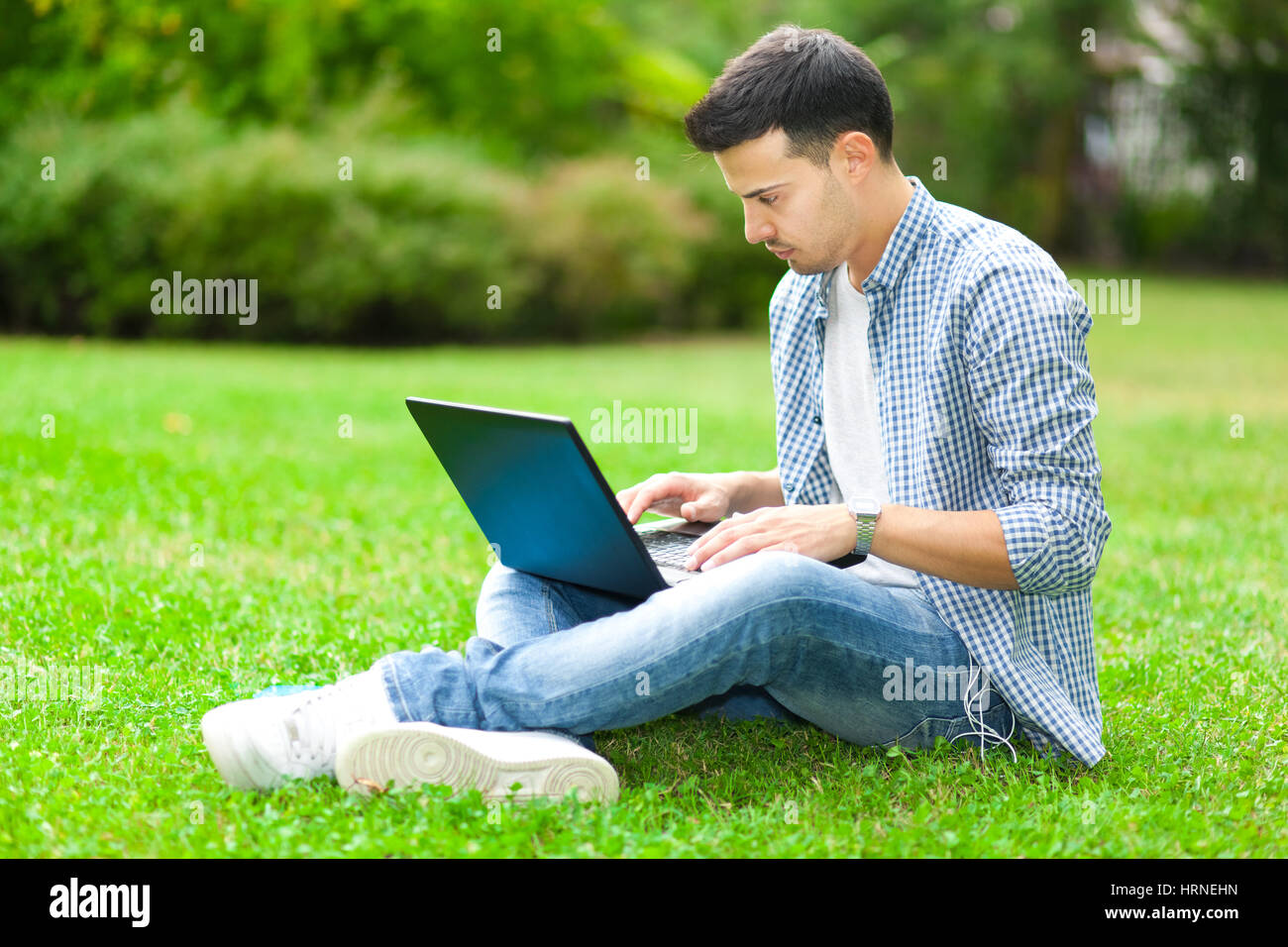 Student using a laptop on the grass Stock Photo - Alamy