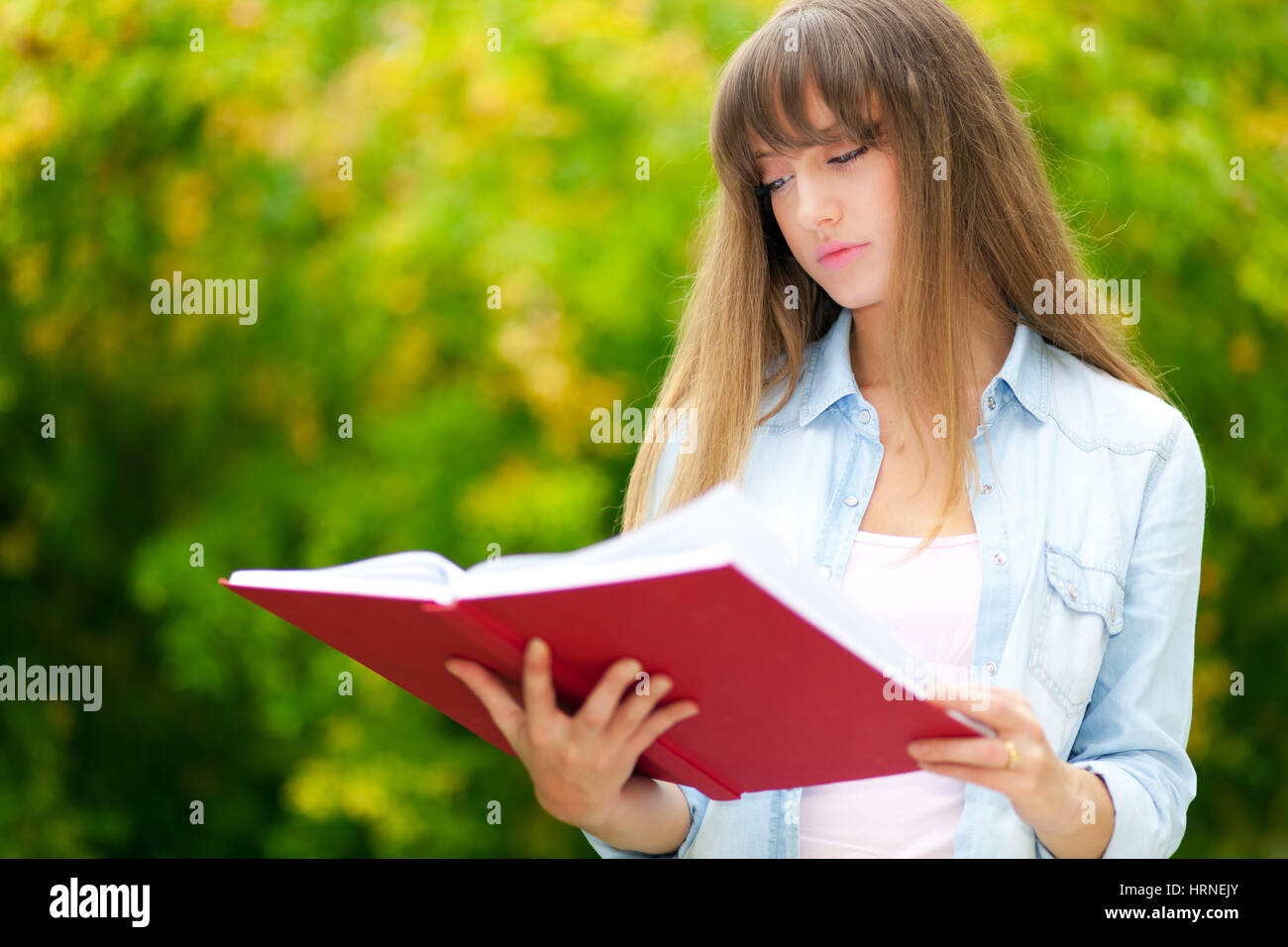 Student outdoor reading a book Stock Photo - Alamy