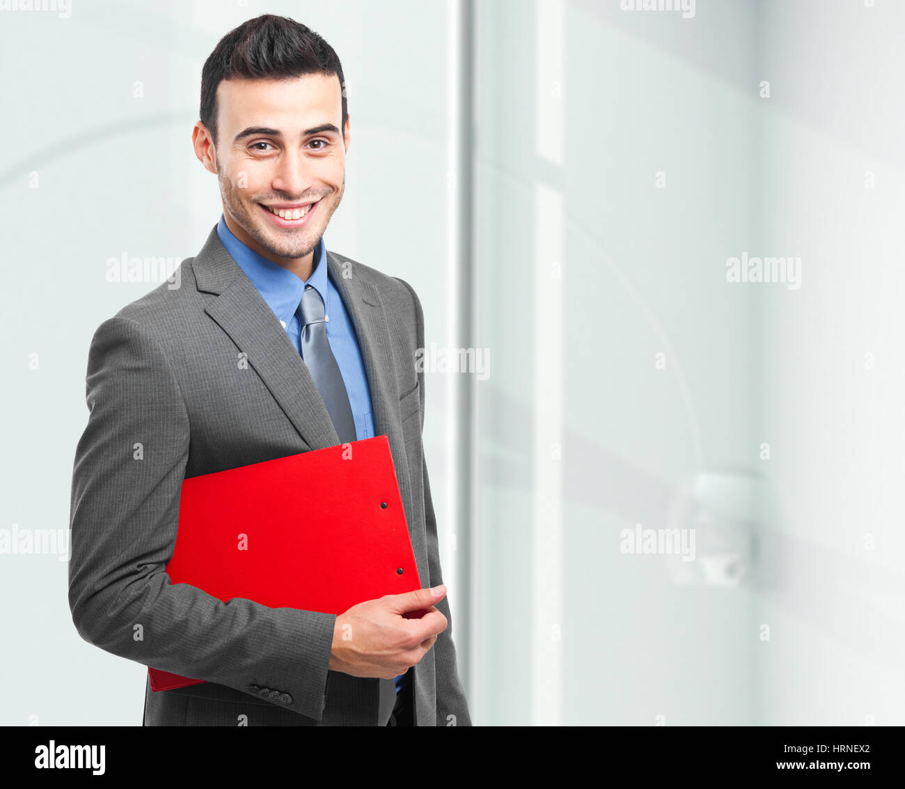 Friendly businessman holding some documents Stock Photo - Alamy