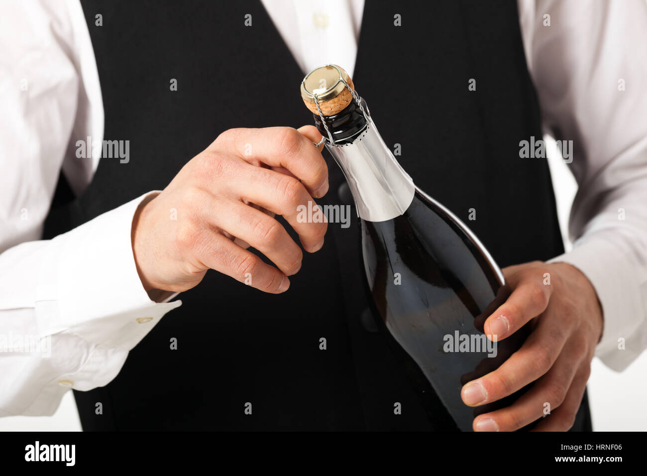 Waiter uncorking a bottle of champagne Stock Photo - Alamy