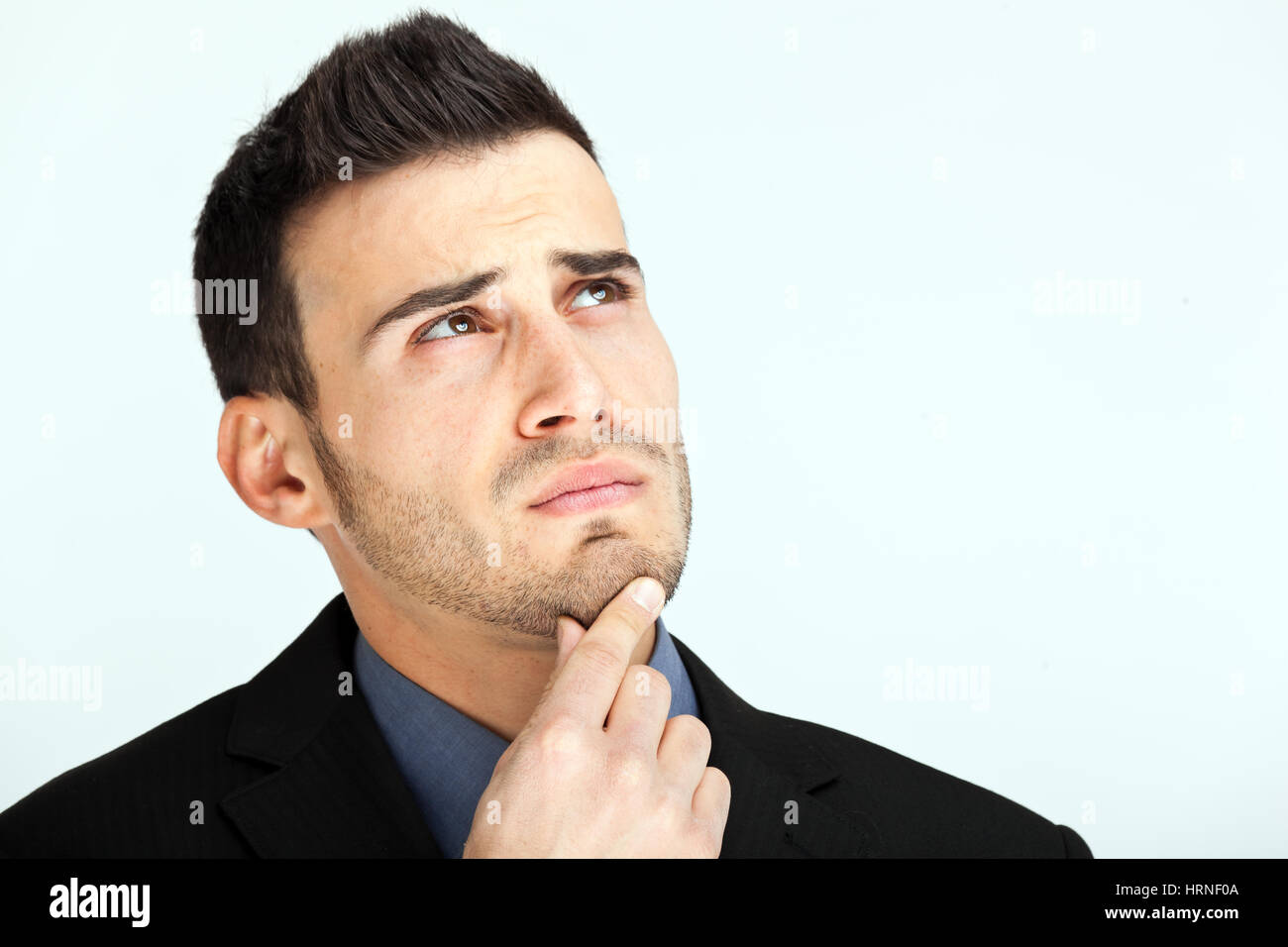 Doubtful businessman looking up Stock Photo - Alamy