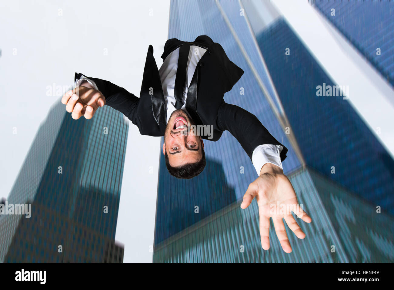 Businessman falling down from a tall skyscraper Stock Photo - Alamy