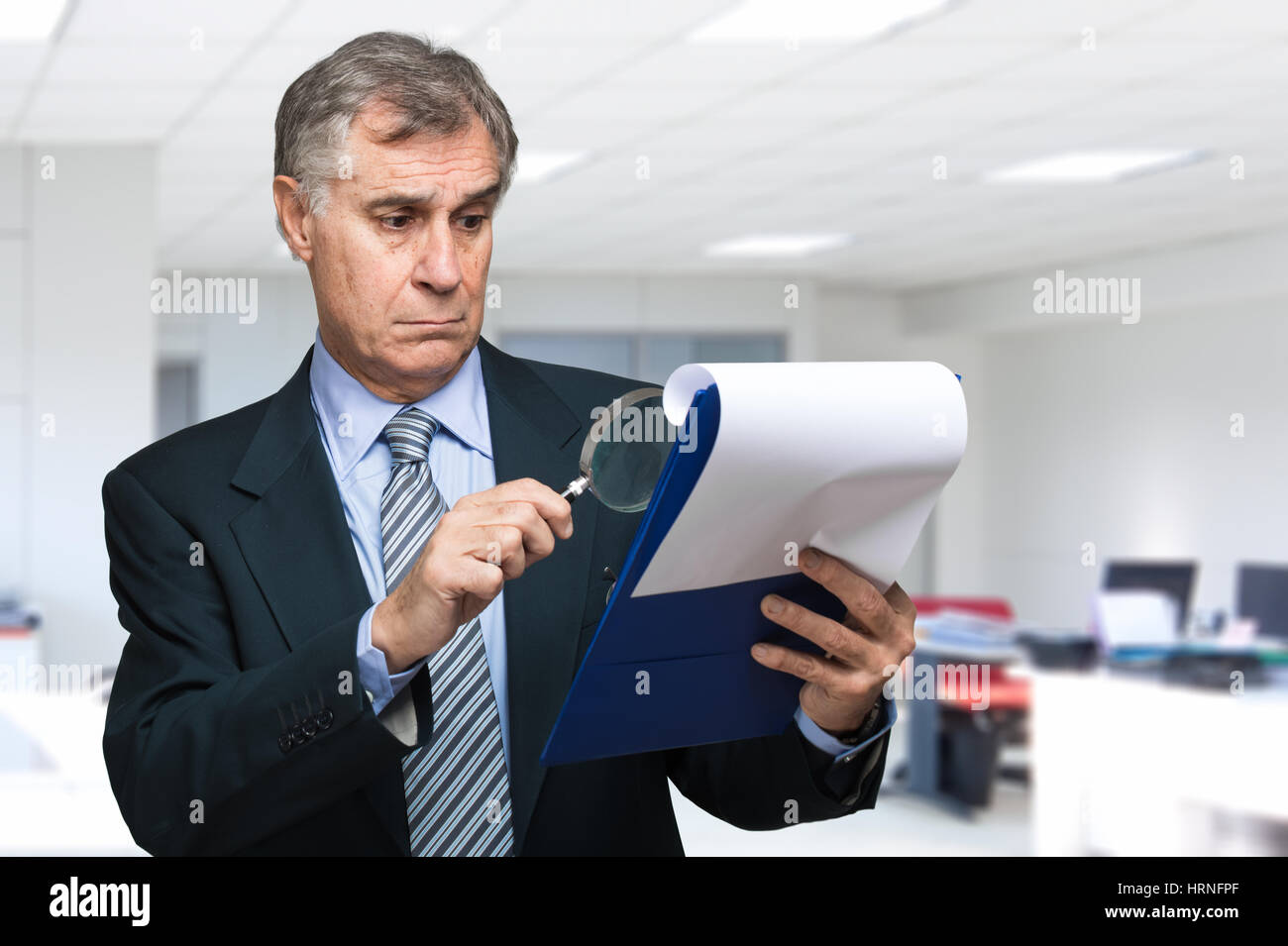 Senior businessman looking at some documents Stock Photo - Alamy