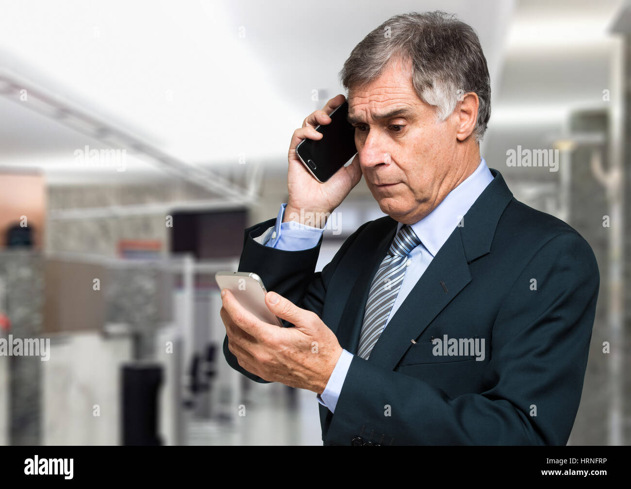 Confused businessman looking mobile phone hi-res stock photography and ...