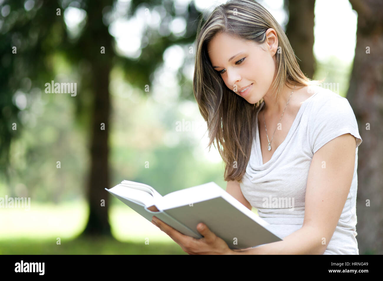 Woman reading a book at the park Stock Photo - Alamy