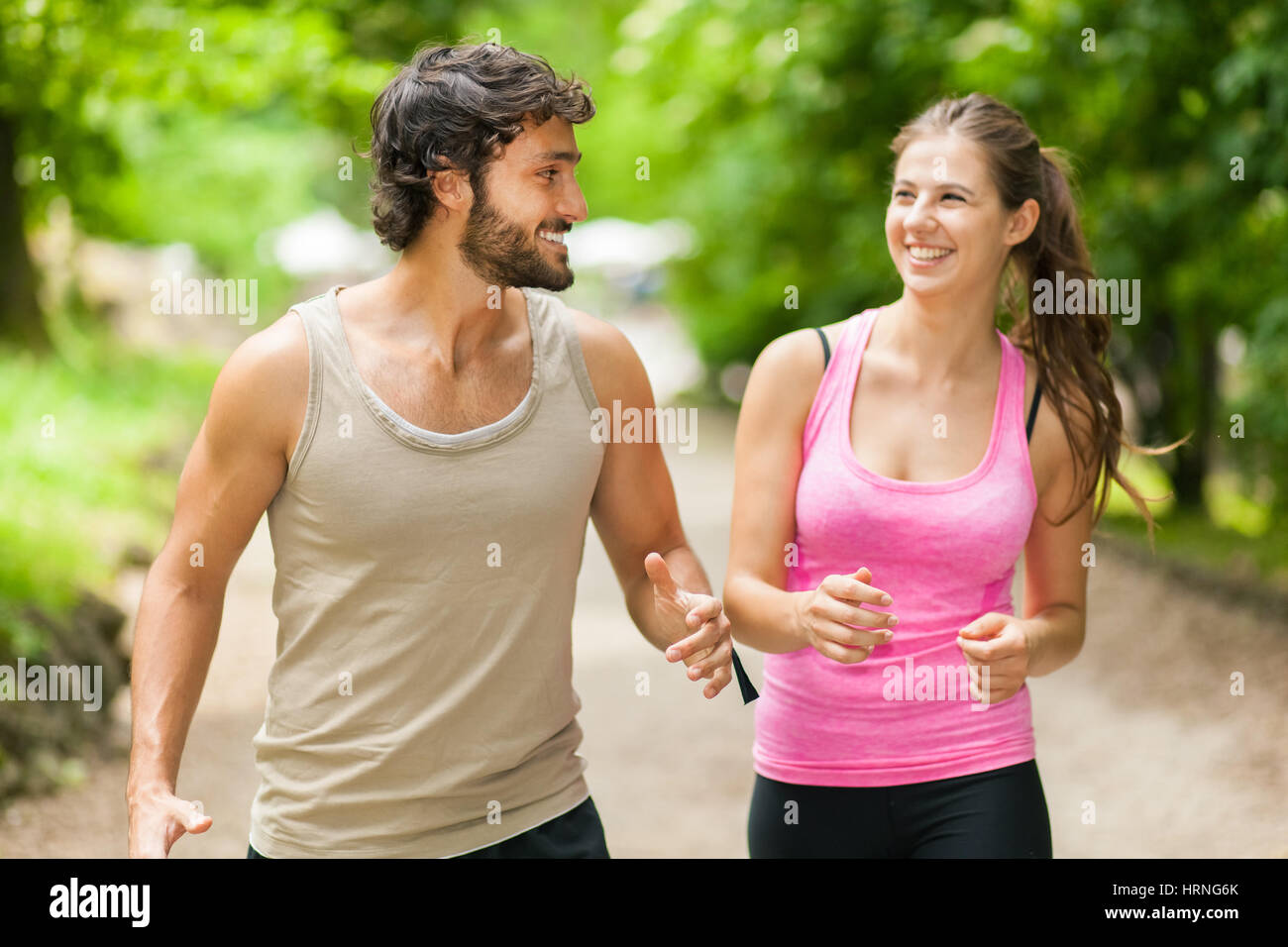 Couple running in a park Stock Photo - Alamy