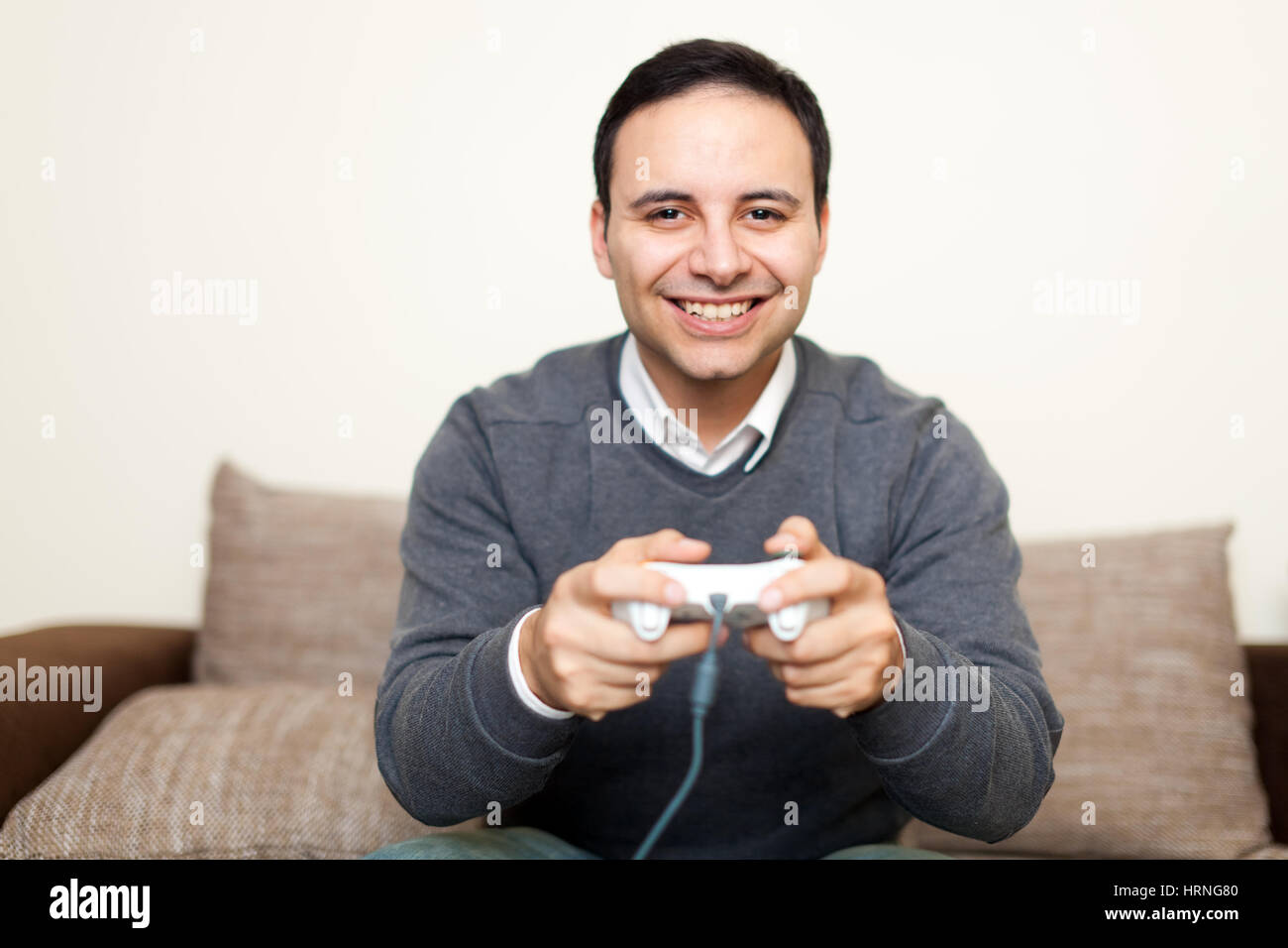 Man playing videogames on his sofa Stock Photo - Alamy
