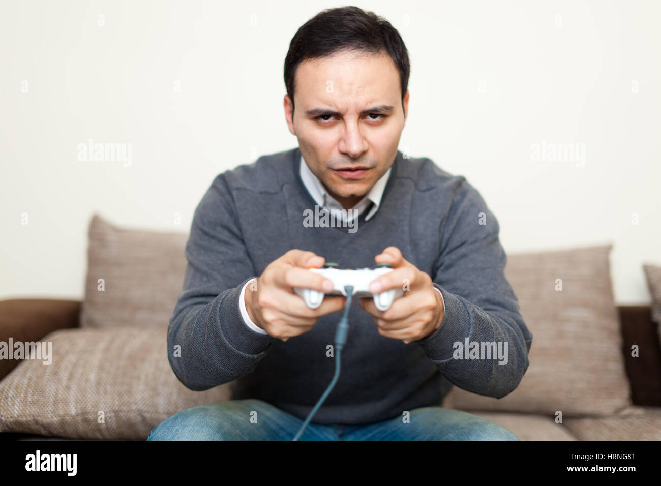 Man playing videogames on his sofa Stock Photo - Alamy