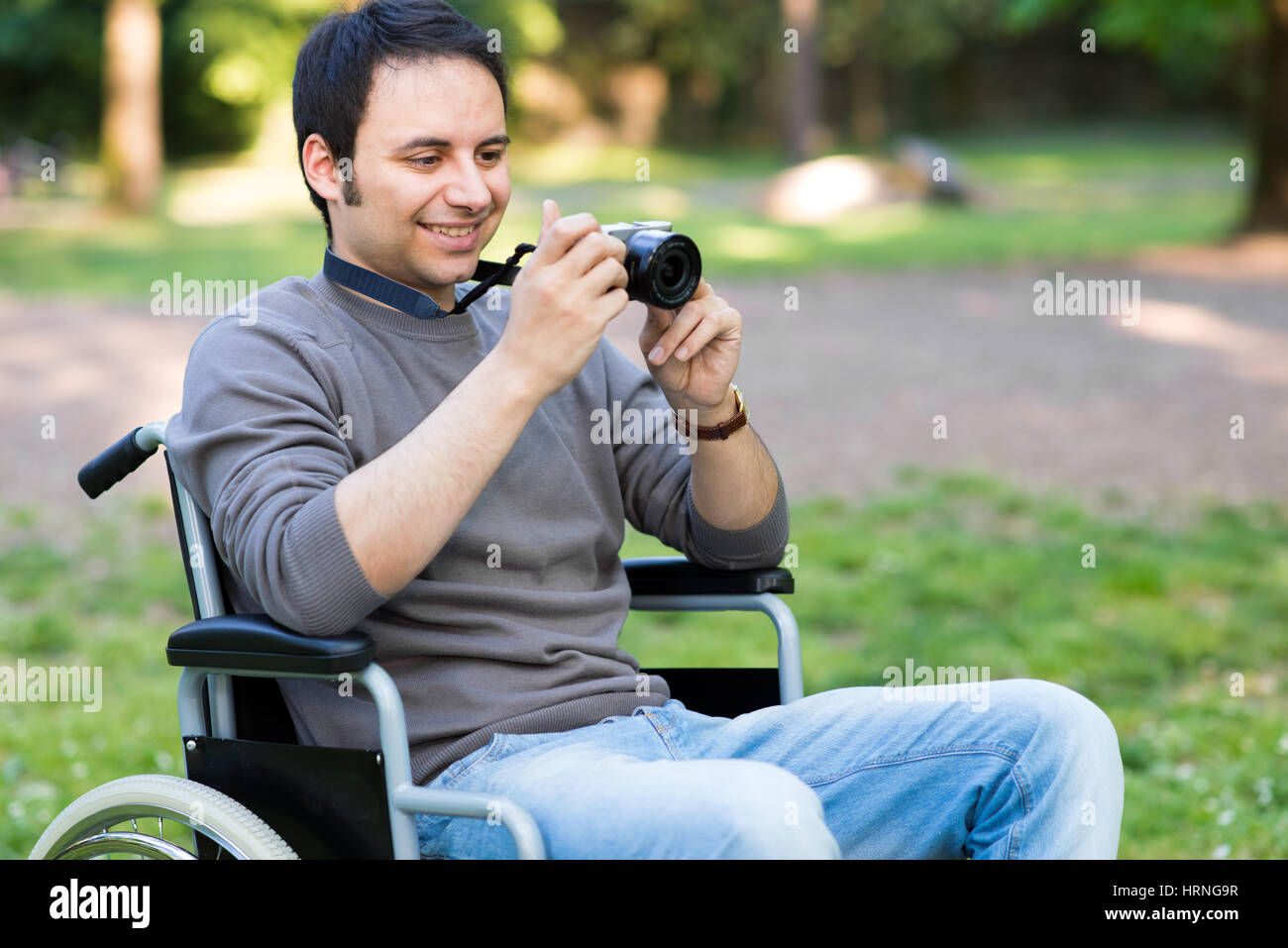 Smiling man using a mirrorless camera Stock Photo - Alamy