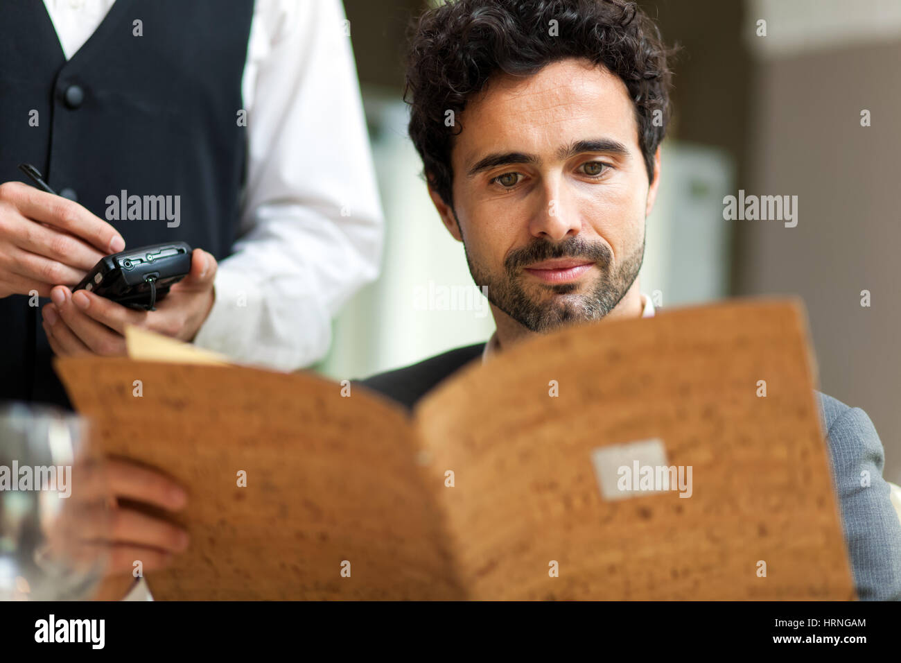 Man looking at a menu in the restaurant Stock Photo - Alamy