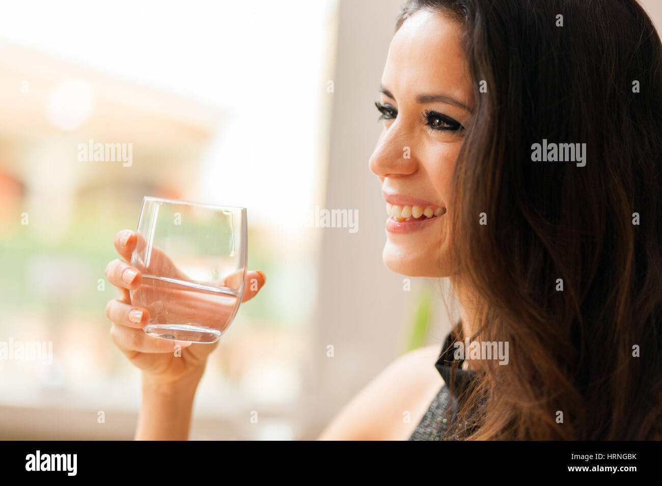 Beautiful young lady drinking water in restaurant Stock Photo - Alamy