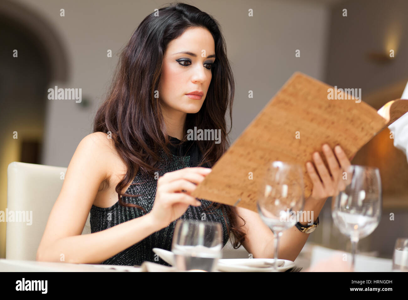 Woman reading the menu at the restaurant Stock Photo - Alamy