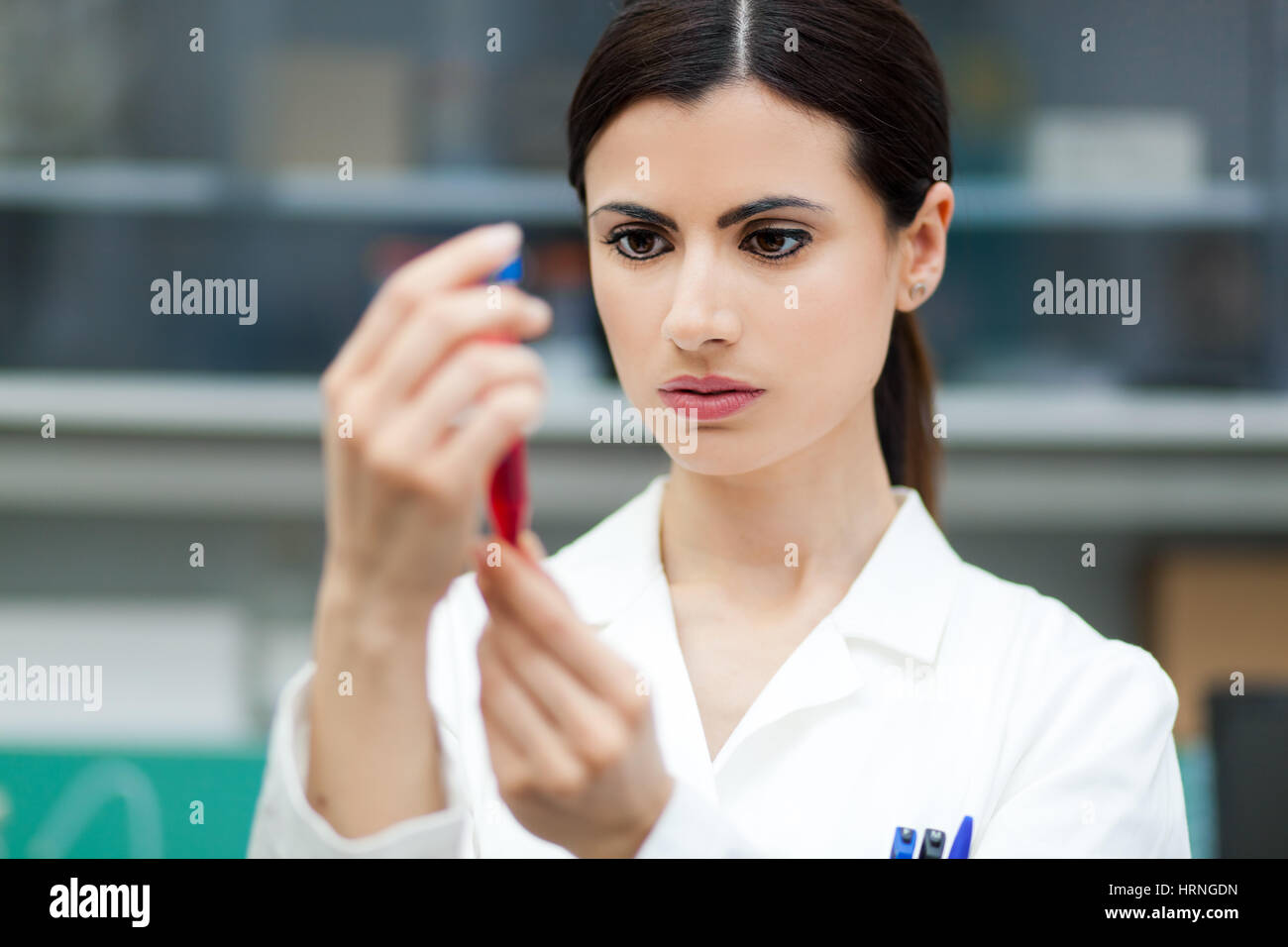 Female researcher analyzing a test tube Stock Photo - Alamy