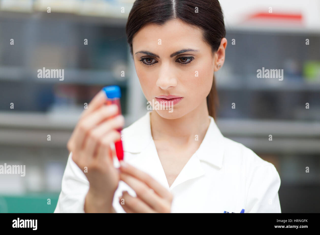 Female scientist looking at a test tube Stock Photo - Alamy