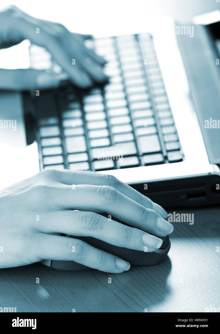 Female hands typing on a laptop, blue toned Stock Photo - Alamy