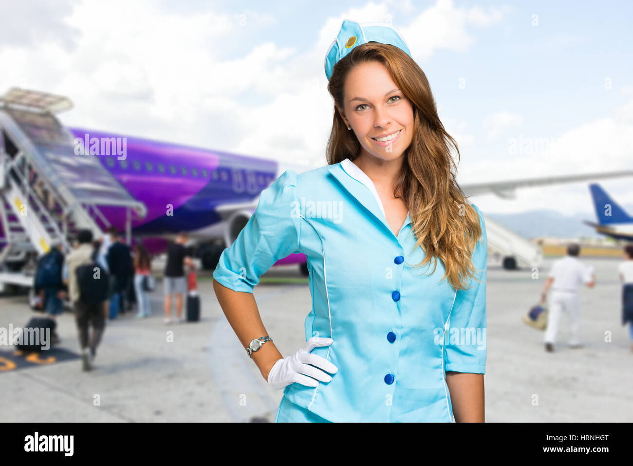 Smiling hostess with airplane on the background Stock Photo - Alamy