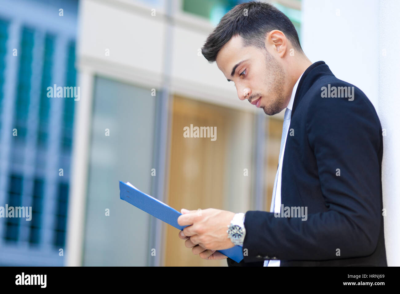 Young business man reading a document Stock Photo - Alamy