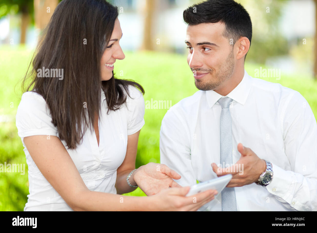 Business people using a tablet outdoor Stock Photo - Alamy