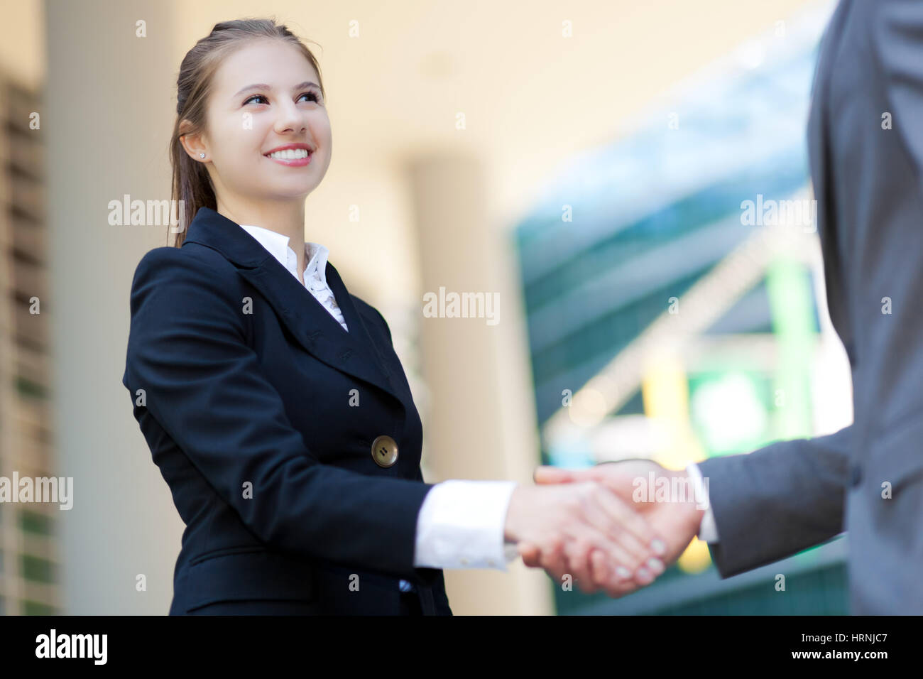 Smiling female manager shaking hands outdoor Stock Photo - Alamy