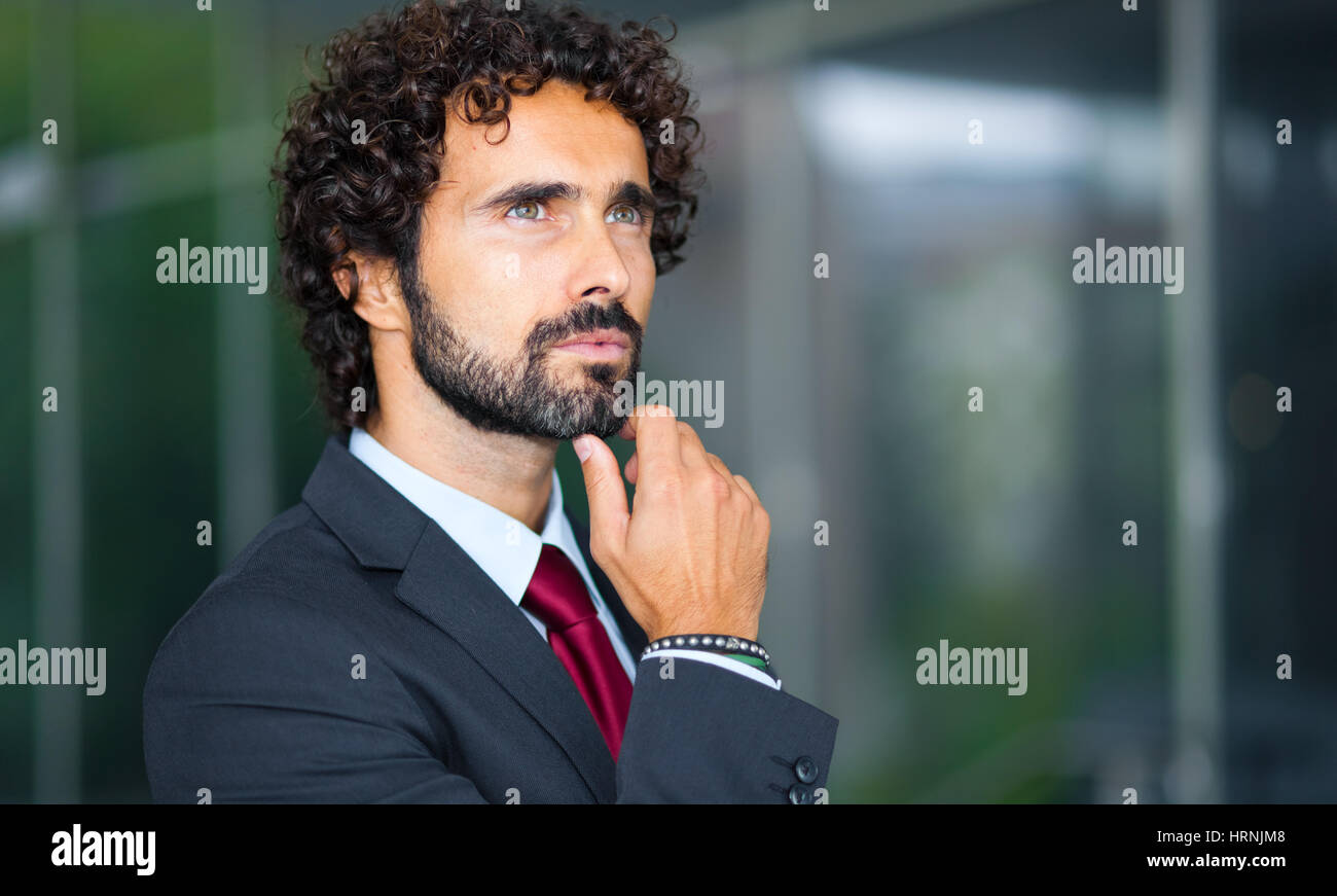 Confident male manager thinking at something Stock Photo - Alamy