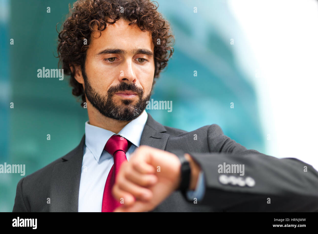 Businessman looking at his watch Stock Photo - Alamy