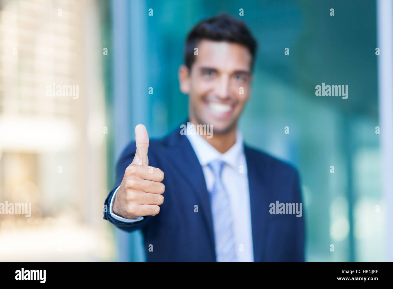 Portrait of a smiling businessman giving thumbs up Stock Photo - Alamy