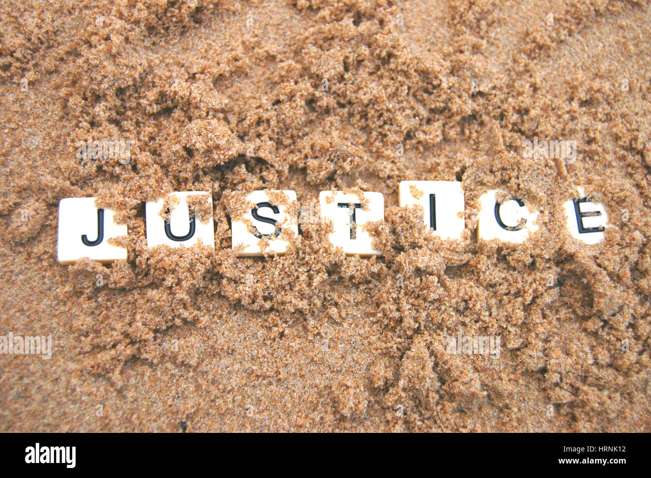 The letters of the word justice being lost in the sand Stock Photo - Alamy