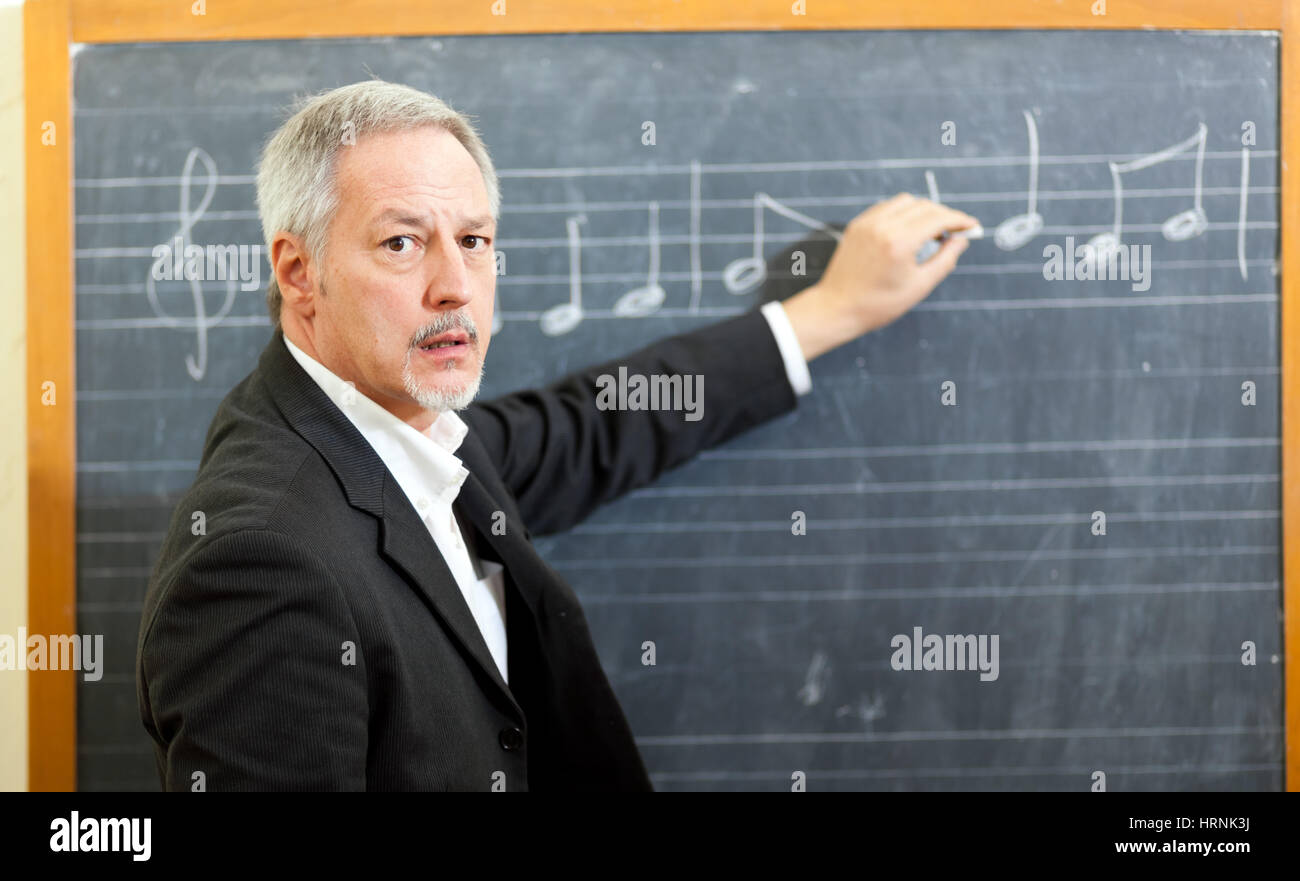 Music teacher writing notes on a blackboard Stock Photo - Alamy