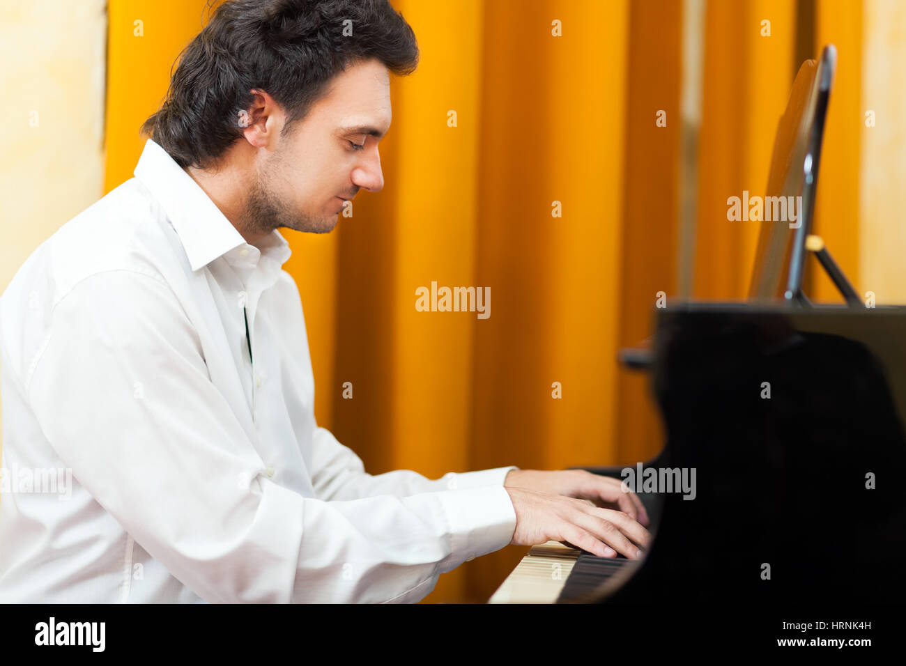 Young man playing the piano Stock Photo - Alamy