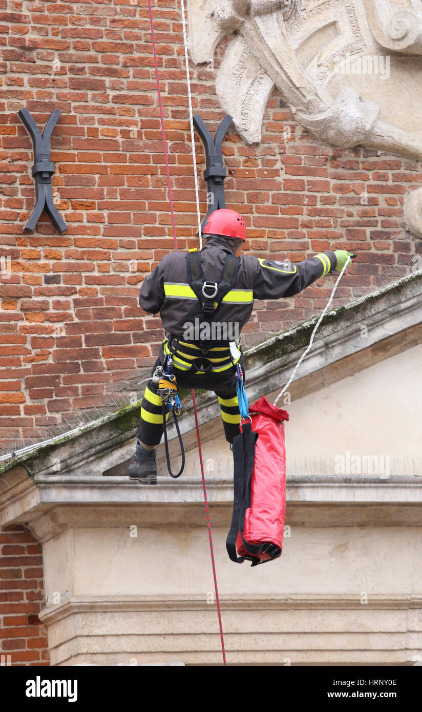 brave firefighters climbing with ropes and climbing equipment on a ...