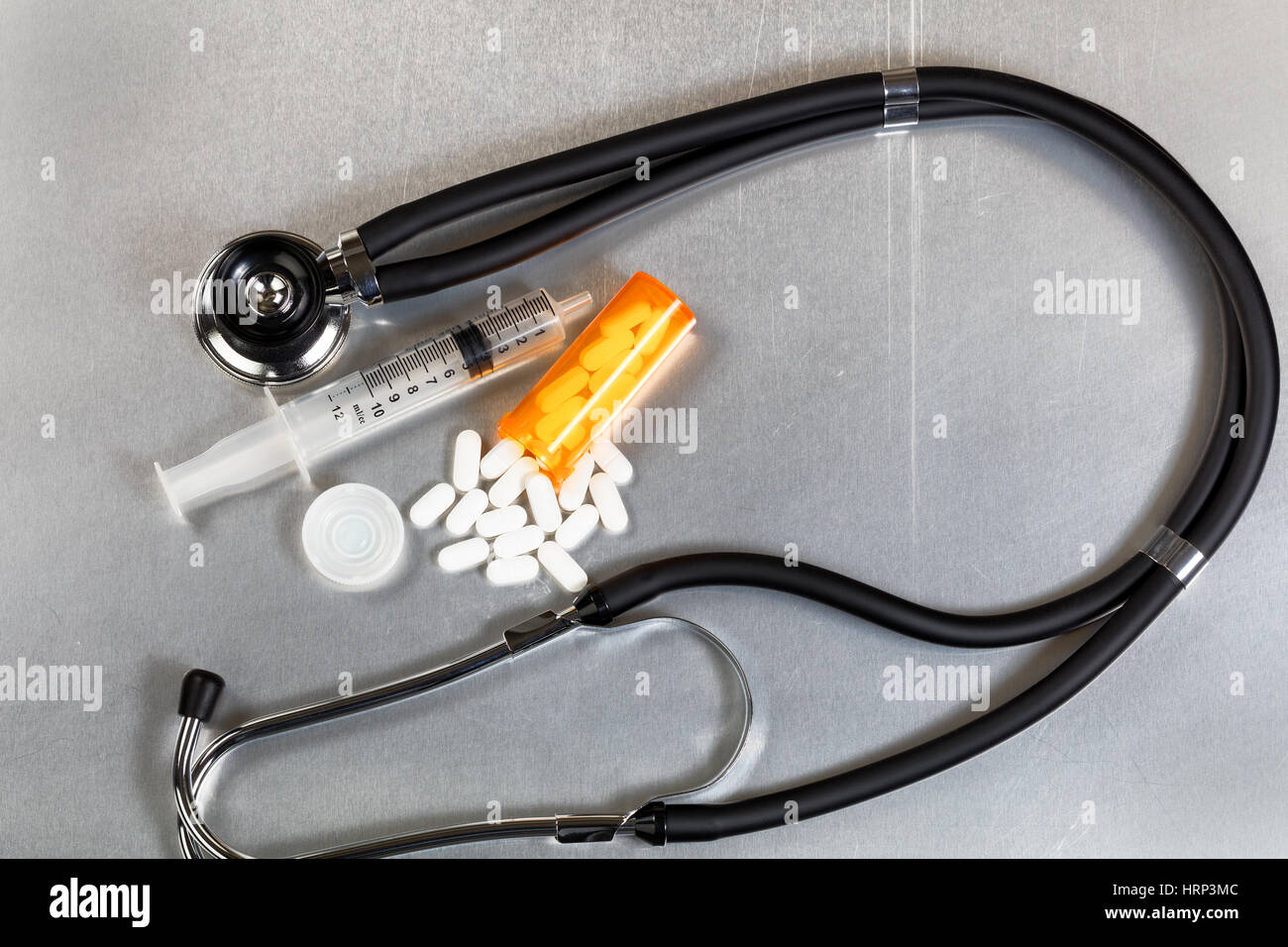 Flat view of painkiller pills with open bottle, stethoscope and syringe ...